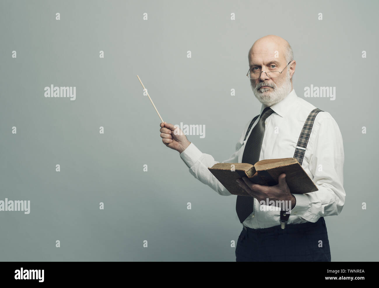 Senior academic professor giving a lecture and pointing at the empty ...