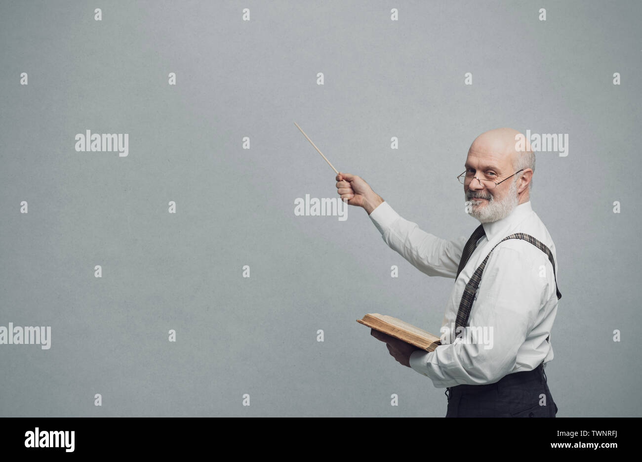Smiling confident professor teaching and pointing at the blackboard ...