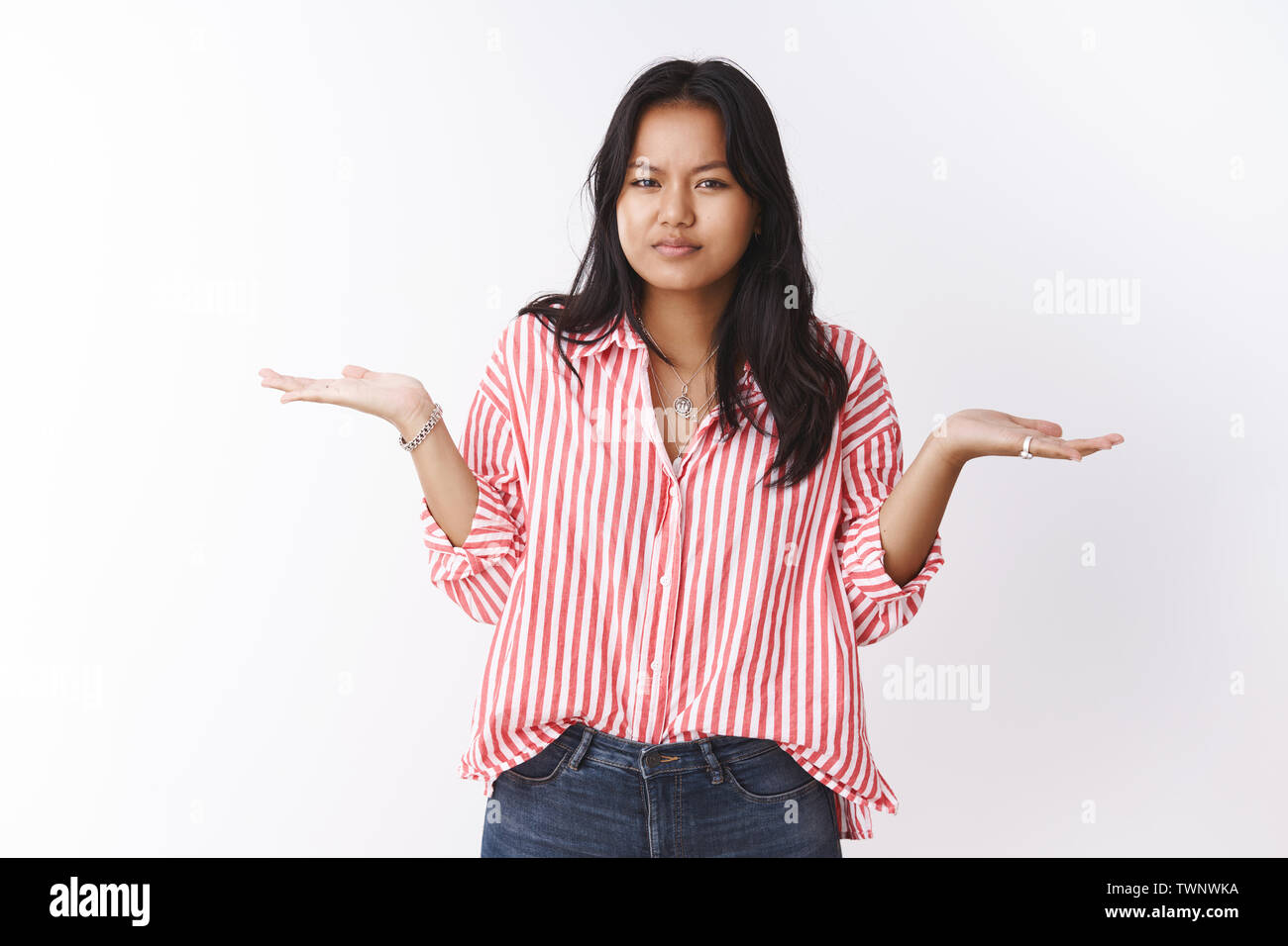 Confused woman standing questioned in clueless pose shrugging and ...