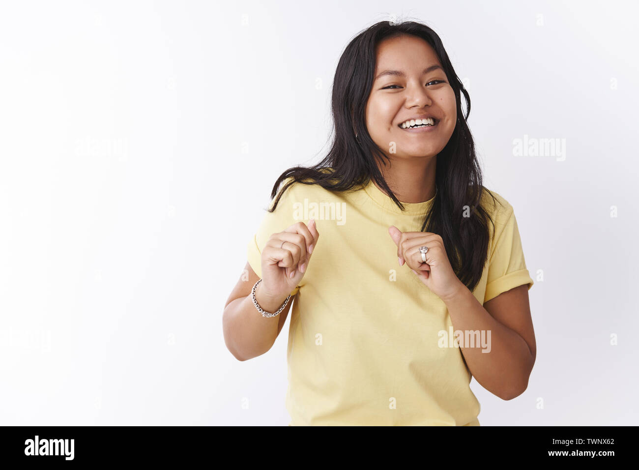 Studio shot of funny and enthusiastic upbeat joyful female in yellow t ...