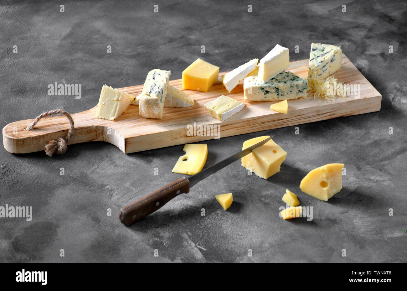 big and small pieces of different types of cheese are lying on a gray ...