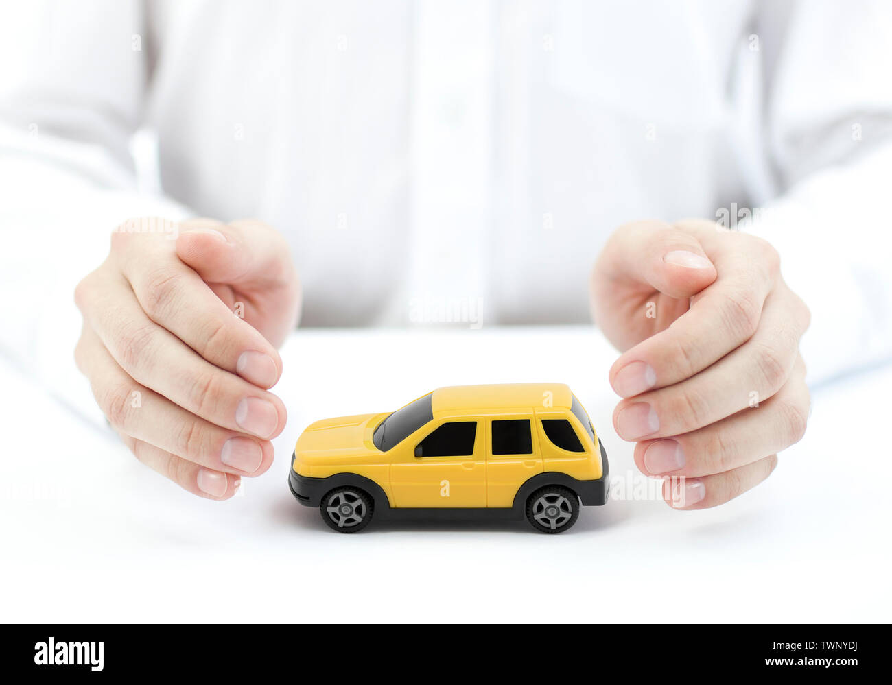 Car insurance concept with yellow car toy covered by hands Stock Photo ...