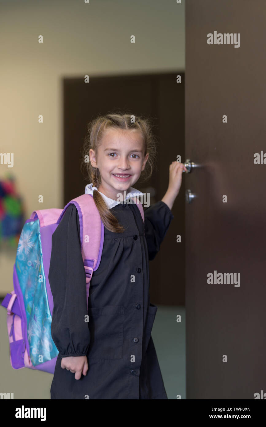 Elementary school student in uniform enters the classroom Stock Photo ...