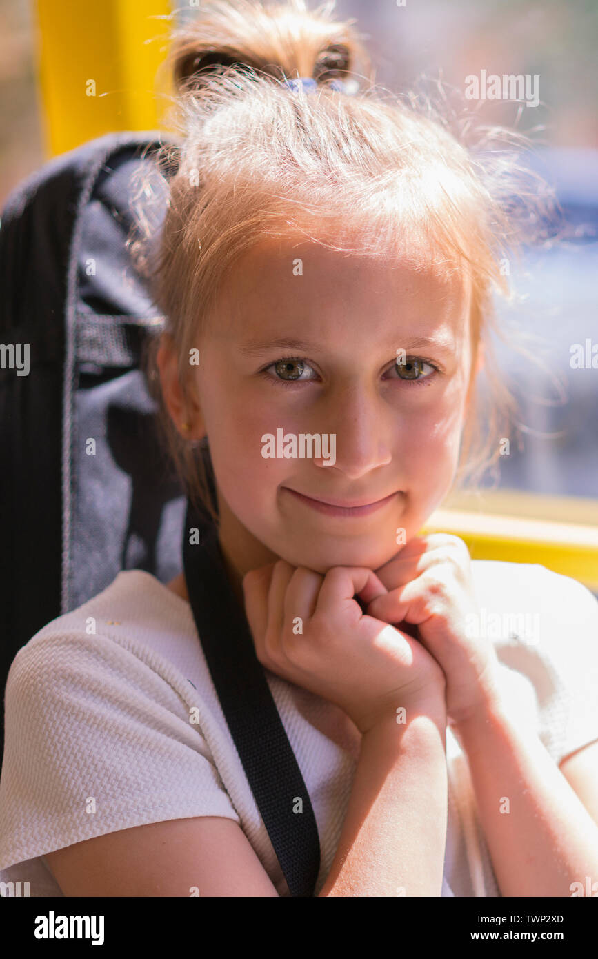 A little girl is going by bus. Schoolgirl sitting in school bus and ...