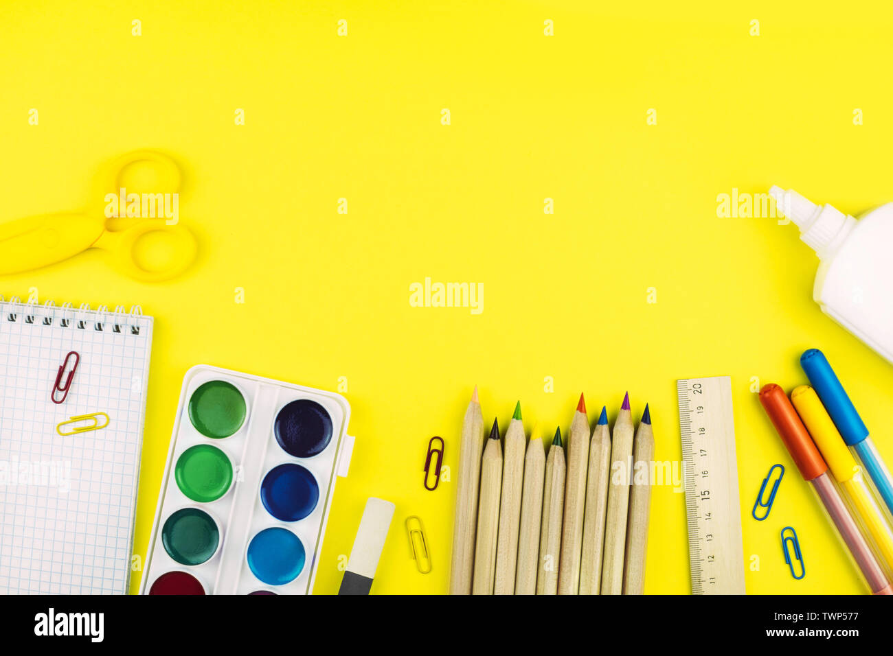 Different school supplies on bright yellow paper background Stock Photo ...