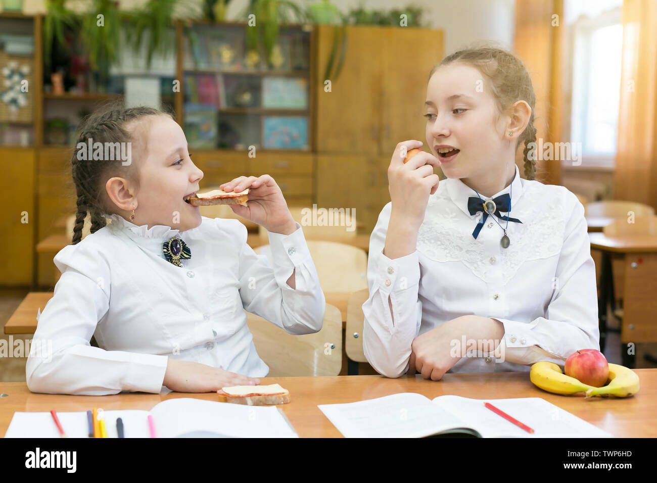 Teen girls having lunch in school class. One girl is vegetarian with ...