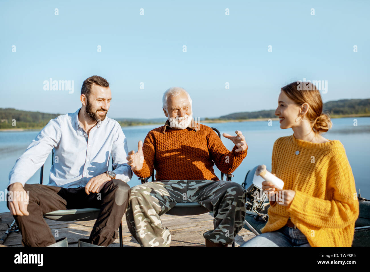 Man and woman having warm conversation with senior grandfather during ...