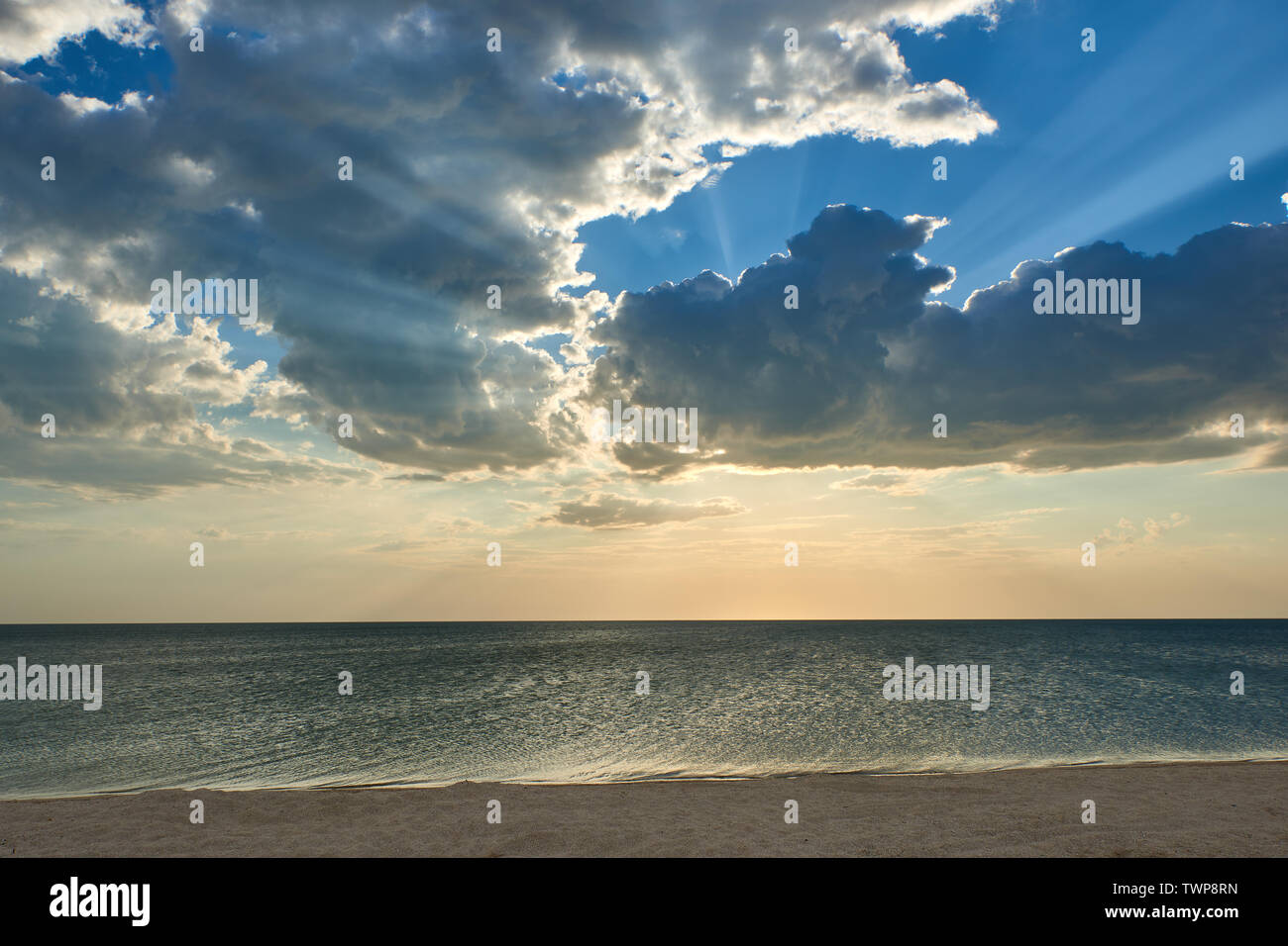 Sunset. Sun rays through the clouds on the sea Stock Photo - Alamy