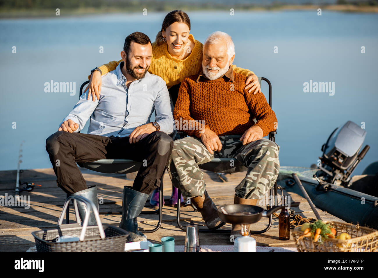 Senior Grandfather Having Warm Conversation With His Adult Son And Daughter During The Picnic