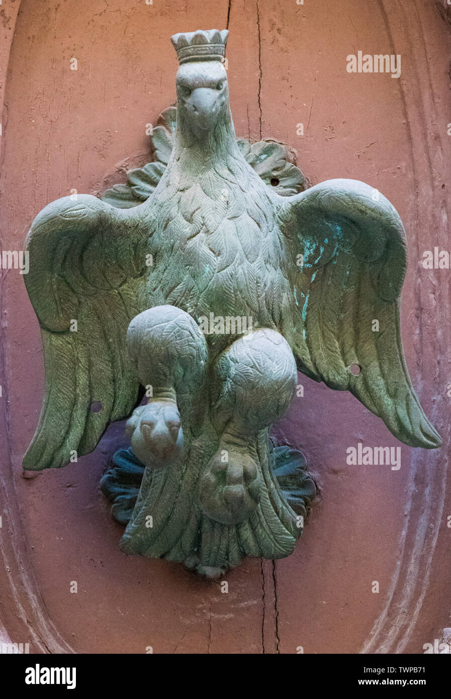 An old style decorative bronze door handle on a wooden door, the ...