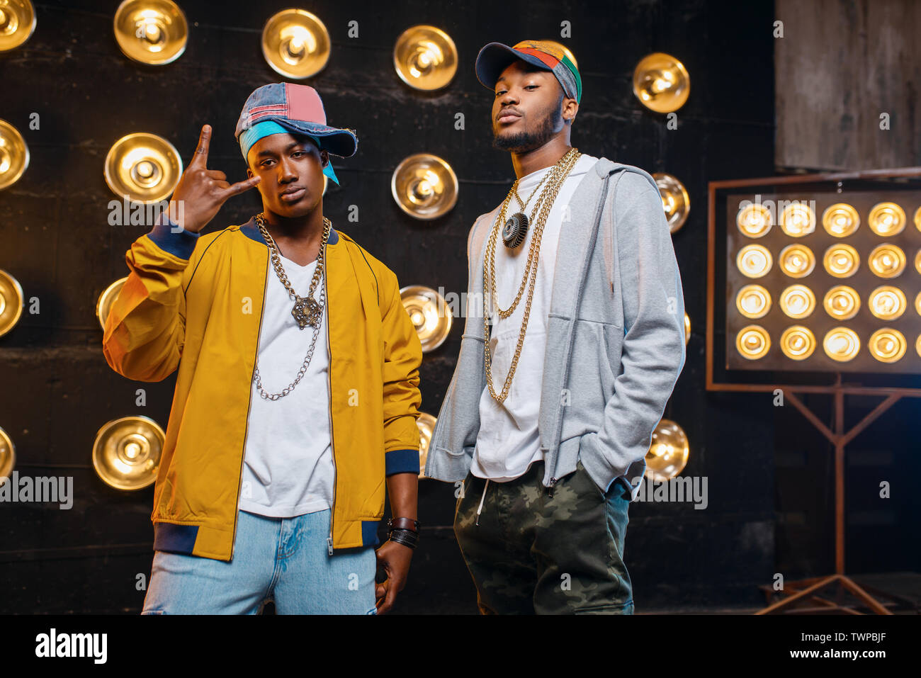 Black rappers in caps on stage with spotlights Stock Photo - Alamy