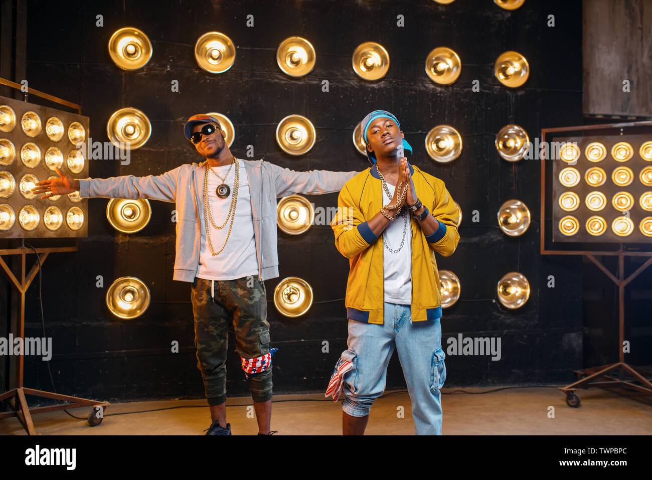 Two black rappers in caps, artists poses on stage Stock Photo - Alamy