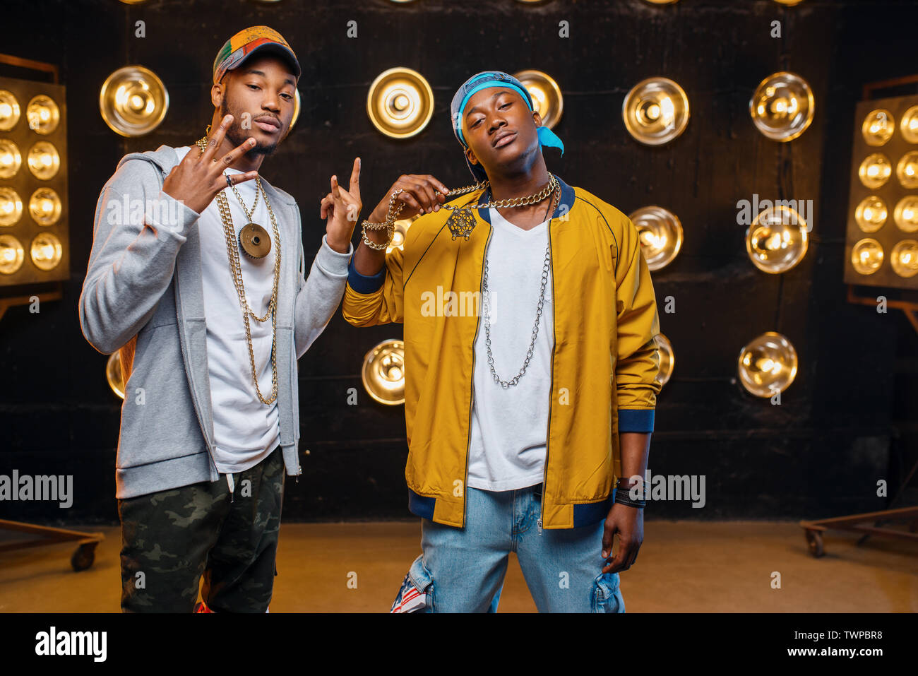 Two black rappers in caps, artists poses on stage Stock Photo - Alamy