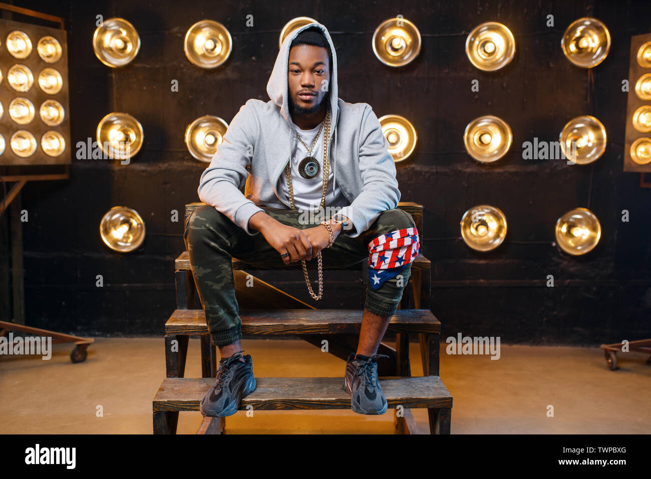 Black rapper in hoodie sitting on the steps Stock Photo - Alamy