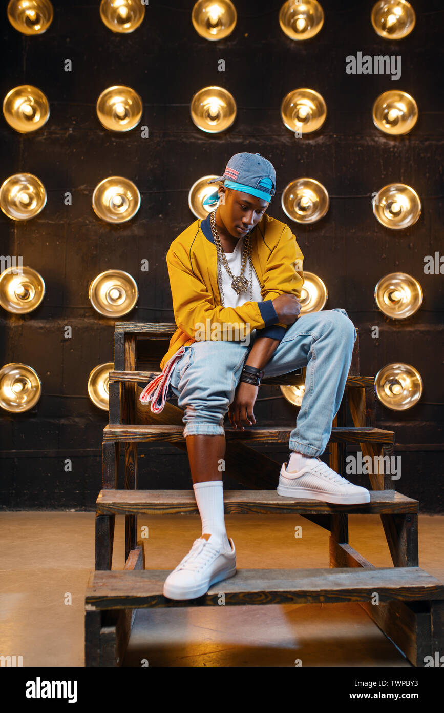 Black rapper in cap sitting on the steps Stock Photo - Alamy