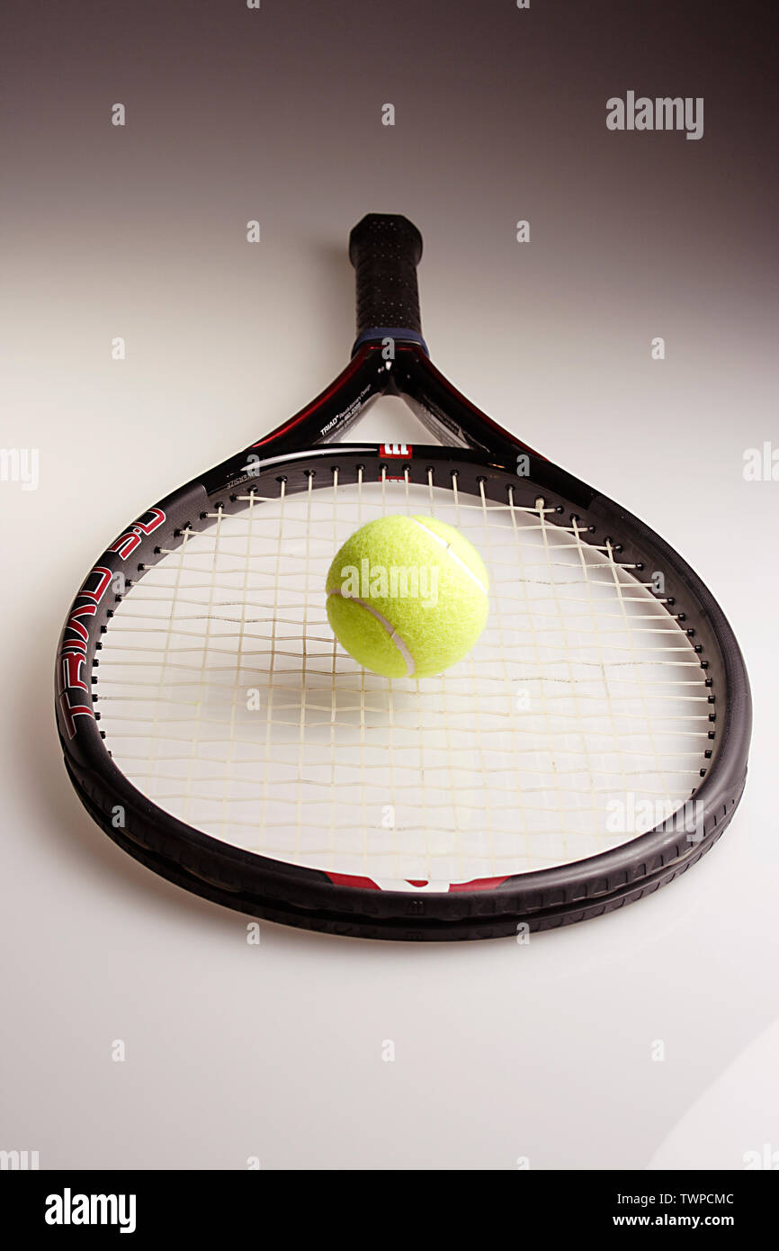 STILL LIFE OF TENNIS BALLS, RACQUET AND WRIST BAND ON A WHITE ...