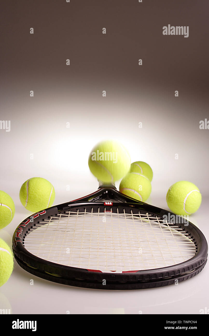 STILL LIFE OF TENNIS BALLS, RACQUET AND WRIST BAND ON A WHITE ...