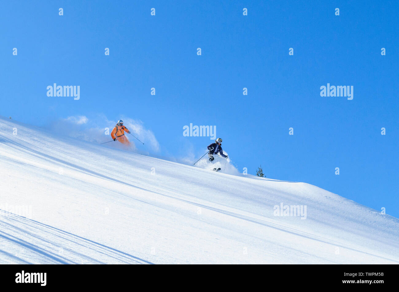 Two skiers enjoying the fantastic powder snow in the alps Stock Photo ...