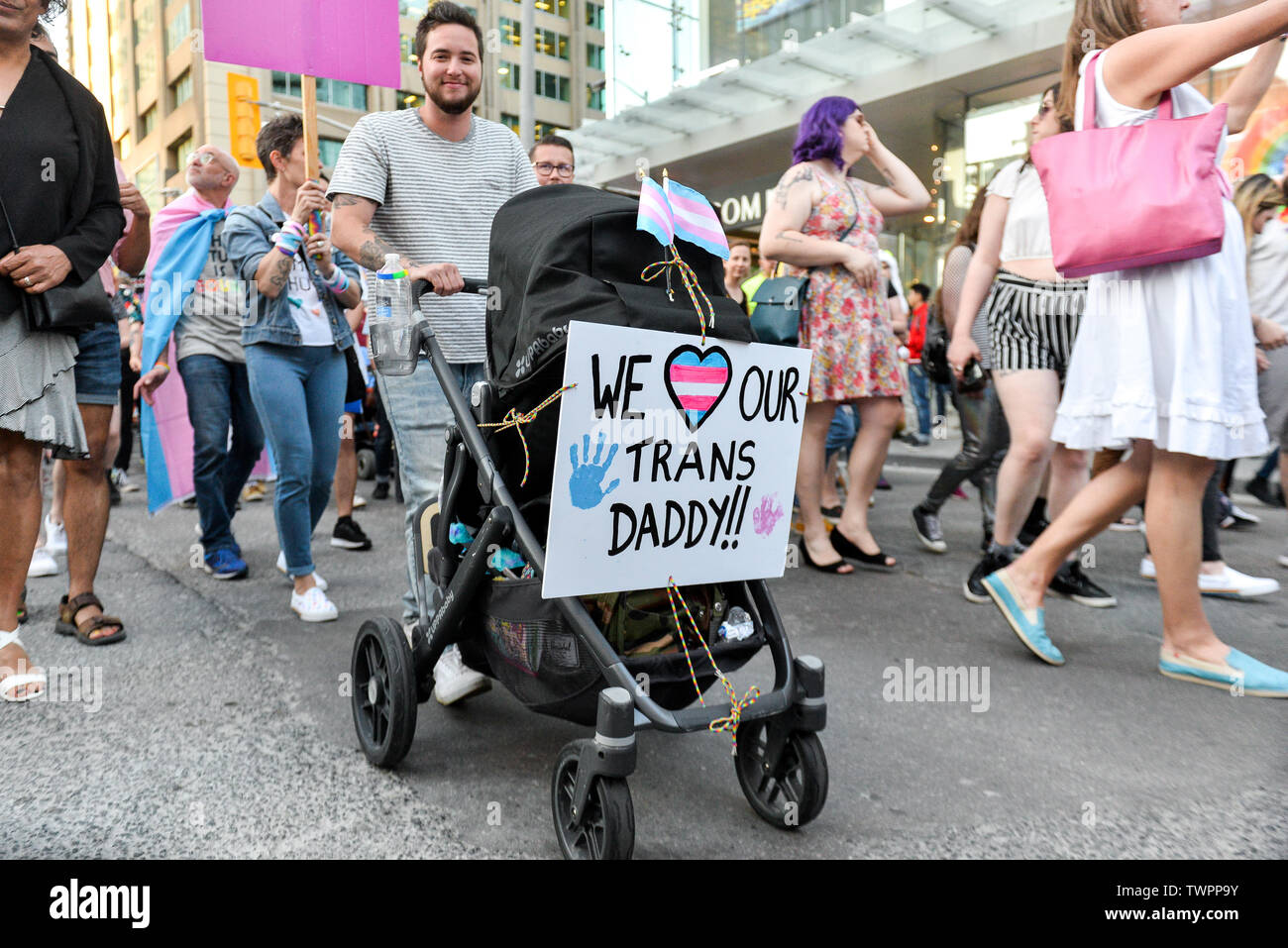 A placard attached to a stroller during the Trans march.Spectators ...