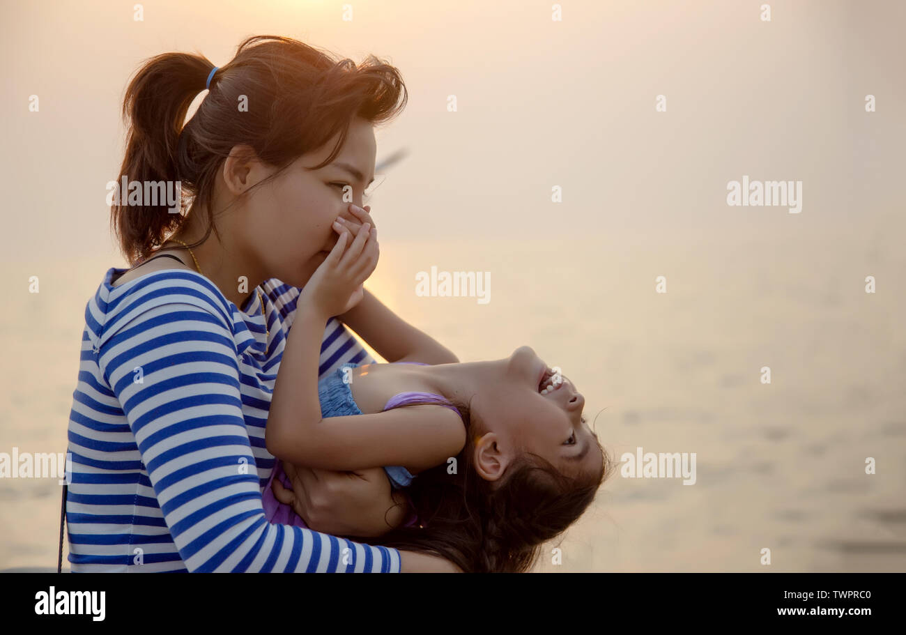 beautiful moment with mom and kid play and hug with sunset warm light. love together family ...