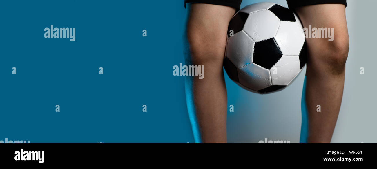 football goalkeeper with dirty knees clamped the ball between his legs ...