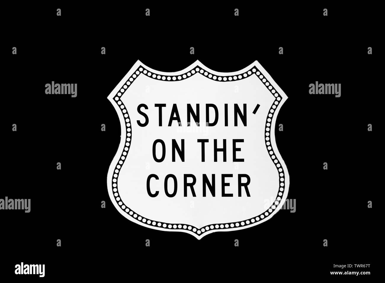Standin' on the corner sign isolated on black Stock Photo - Alamy