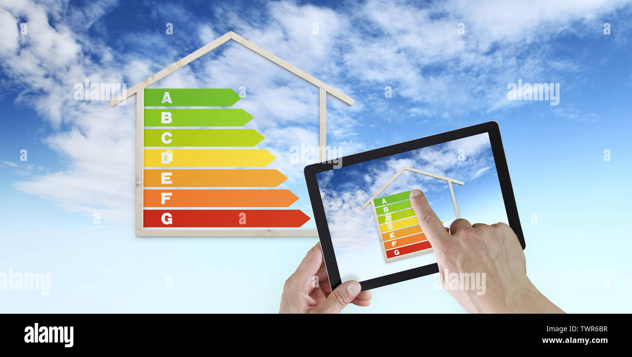 hand touch screen of digital tablet with house shape and energy ...
