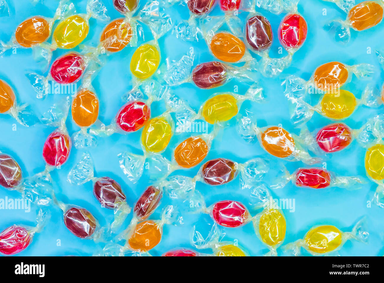 Pattern of a variety of multi-colored candy on electric blue background ...