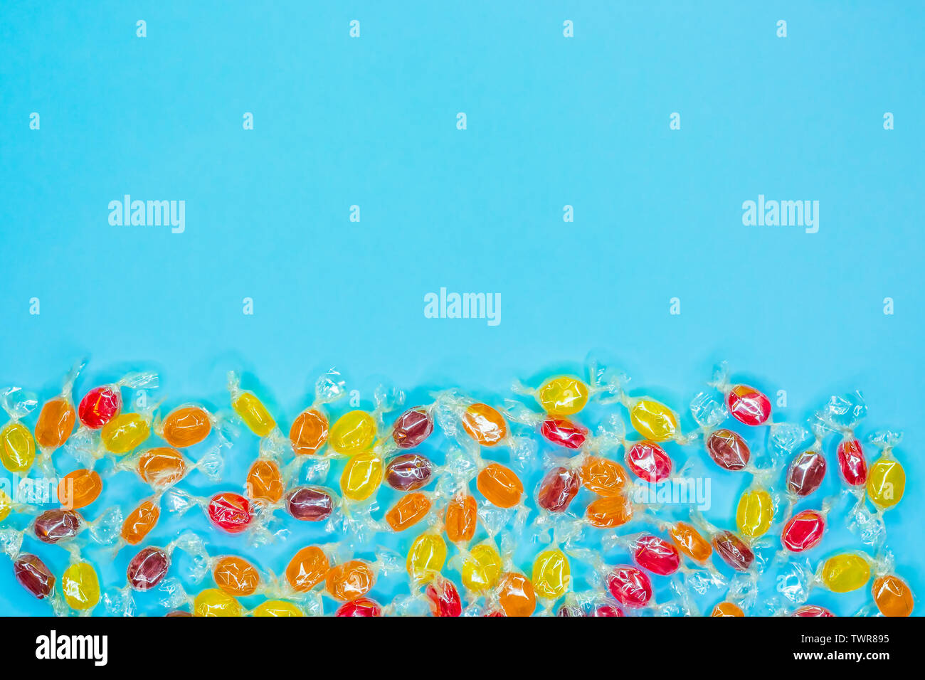 Bright multicolored candies in wrappers of transparent mica, sweets on ...