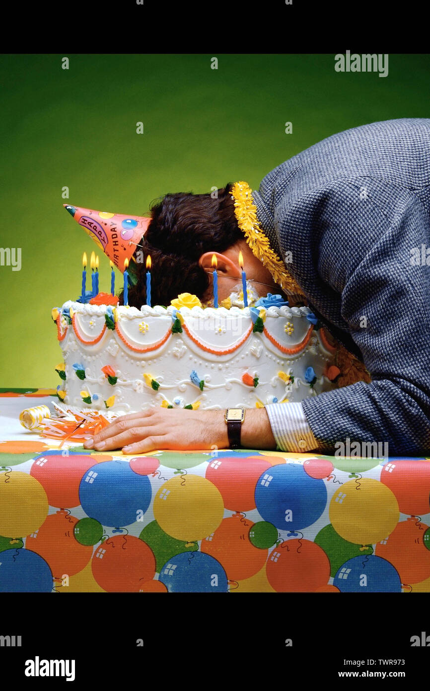 Man his head buried in a birthday cake Stock Photo - Alamy