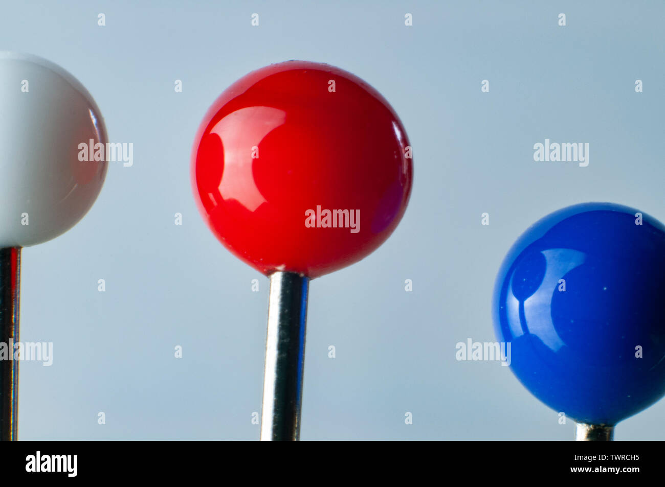 macrophotography of sphere shaped glass pin heads in white, red and ...