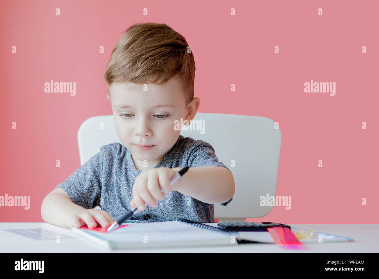 Portrait of cute kid boy at home making homework. Little concentrated ...