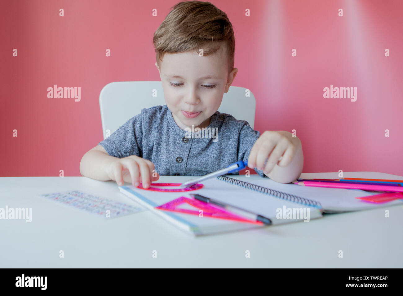 Portrait of cute kid boy at home making homework. Little concentrated ...