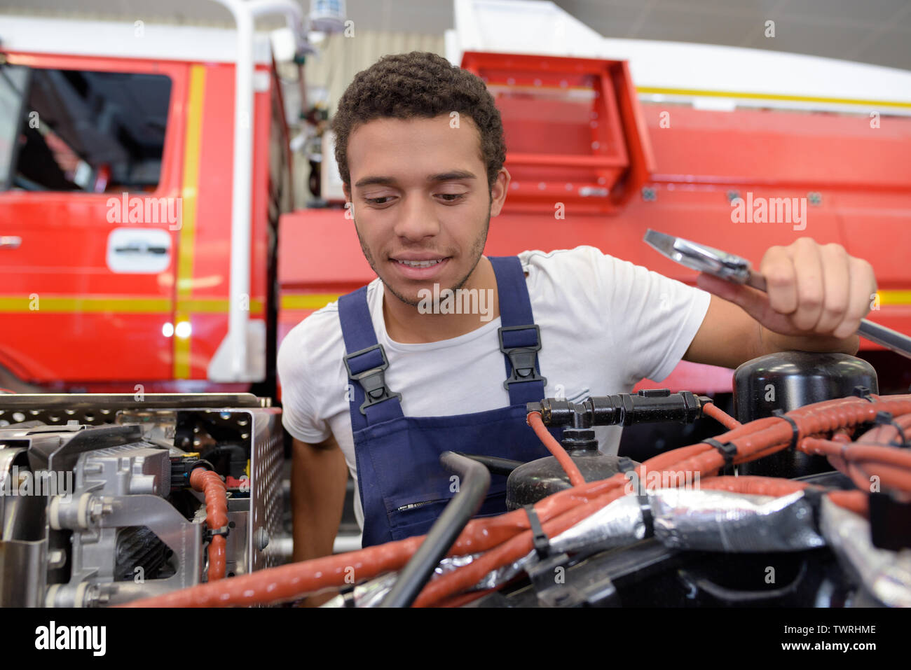 happy male firefighter fixing truck in a fire station Stock Photo - Alamy