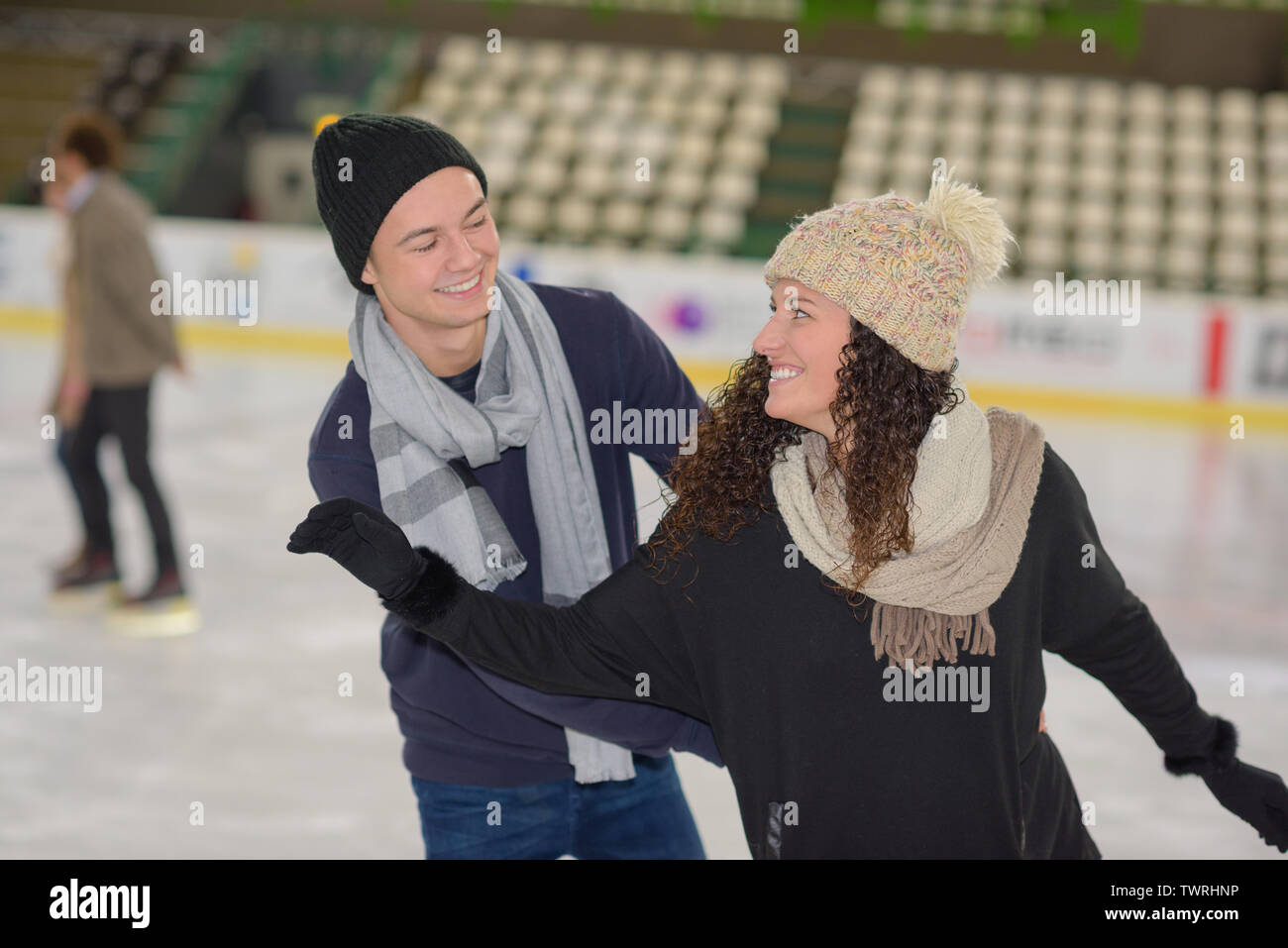 man helping girl to stand on the ice rink Stock Photo - Alamy