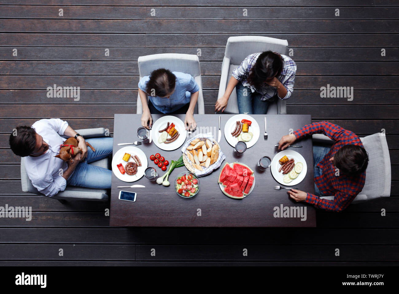 Four friends having dinner together, top view Stock Photo - Alamy