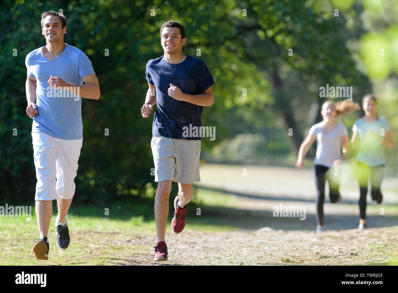 healthy young people running on mountain trail in morning Stock Photo ...