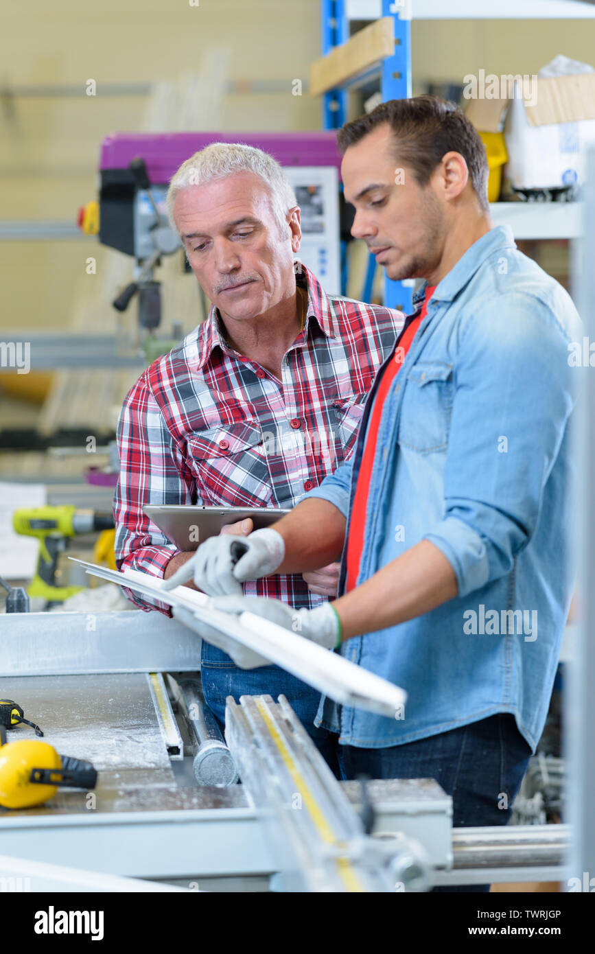 boss and worker together in a carpenters workshop Stock Photo - Alamy