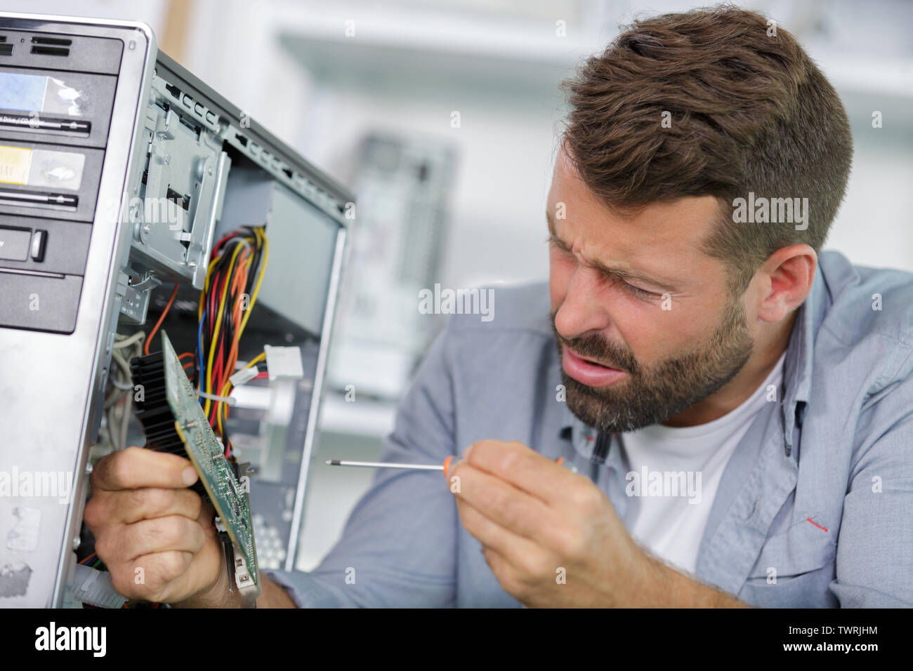 man repairing broken pc with a screw driver Stock Photo - Alamy