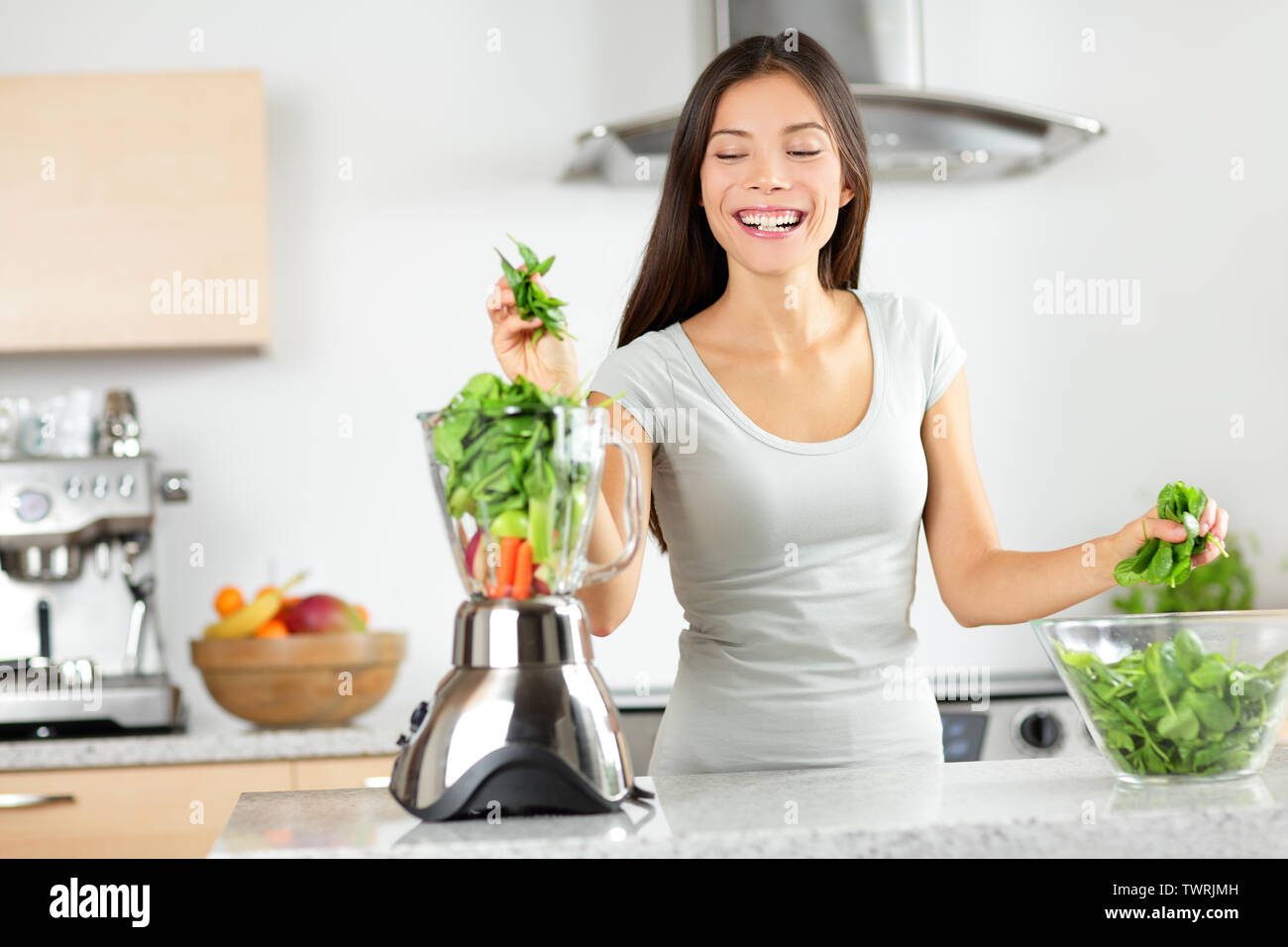Green smoothie woman making vegetable smoothies with blender home in ...