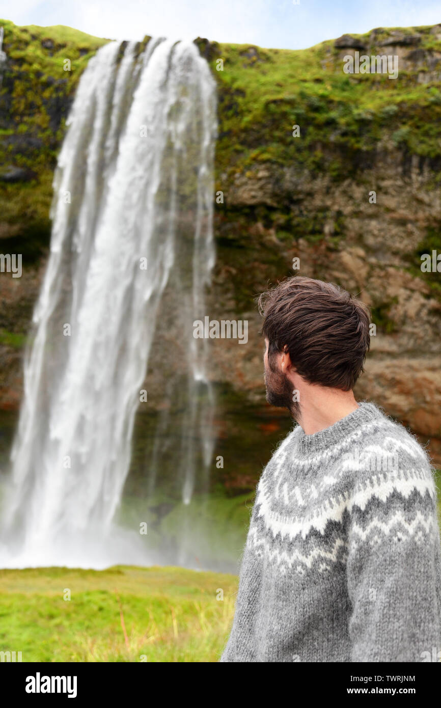 Icelandic sweater man by waterfall on Iceland outdoor smiling. Portrait ...