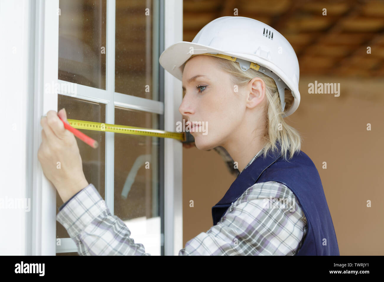 female worker measuring window Stock Photo - Alamy