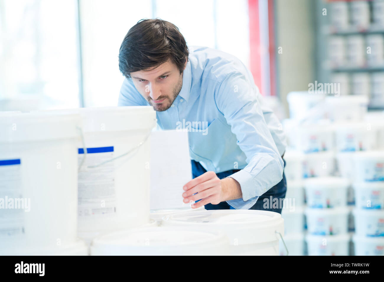 man choosing paint in a diy store Stock Photo - Alamy