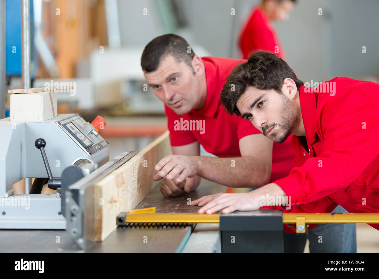 men cutting wood with a machine Stock Photo - Alamy