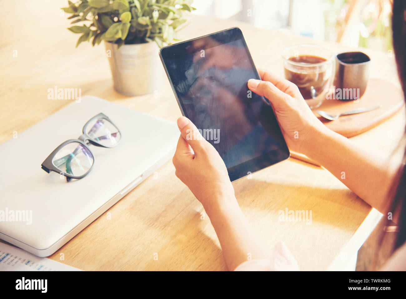 Beautiful business working woman using Ipad while working with laptop ...