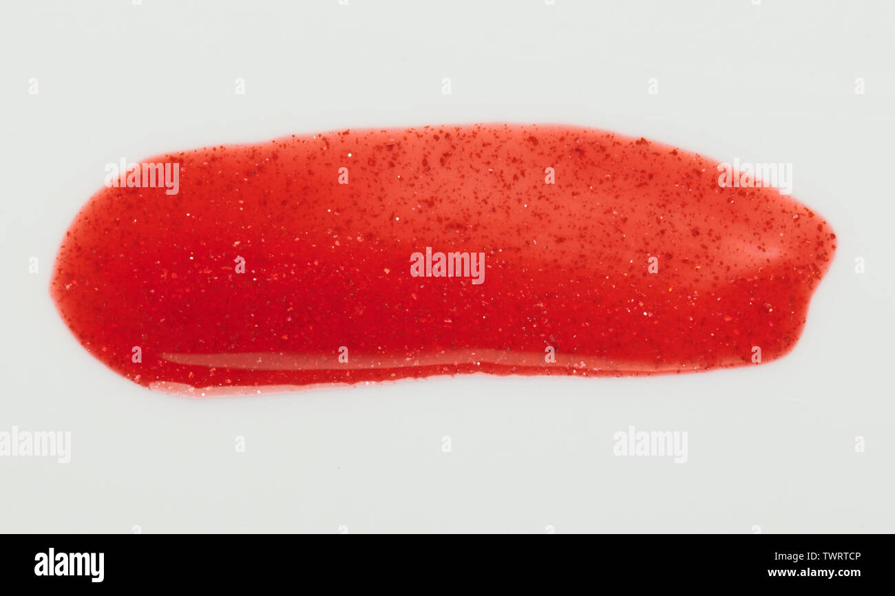 Deep red sparkle paint stroke isolated on white background close up ...