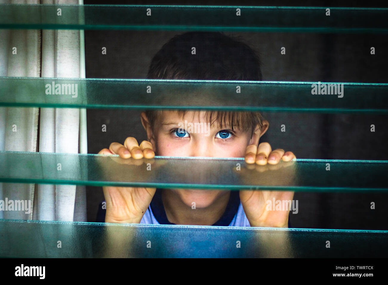 boy looking through window Stock Photo - Alamy