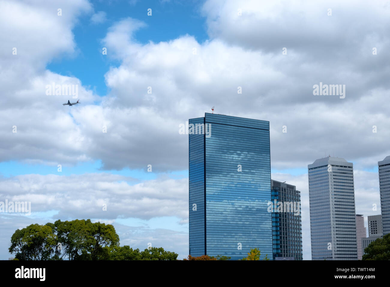 Skyscraper reflection cloud in downtown and airplane flying on blue sky ...