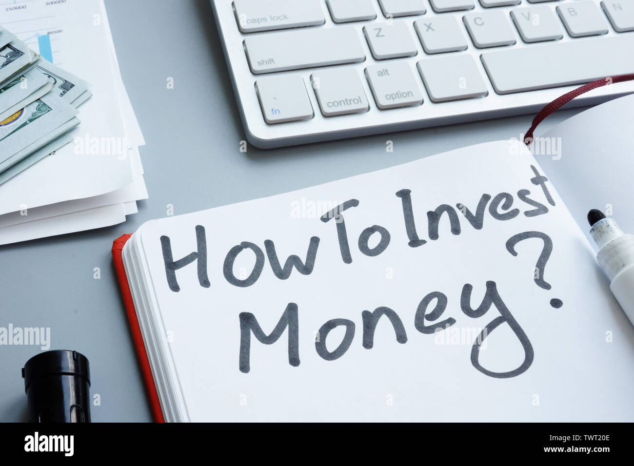 How to invest money. Note pad and cash Stock Photo - Alamy