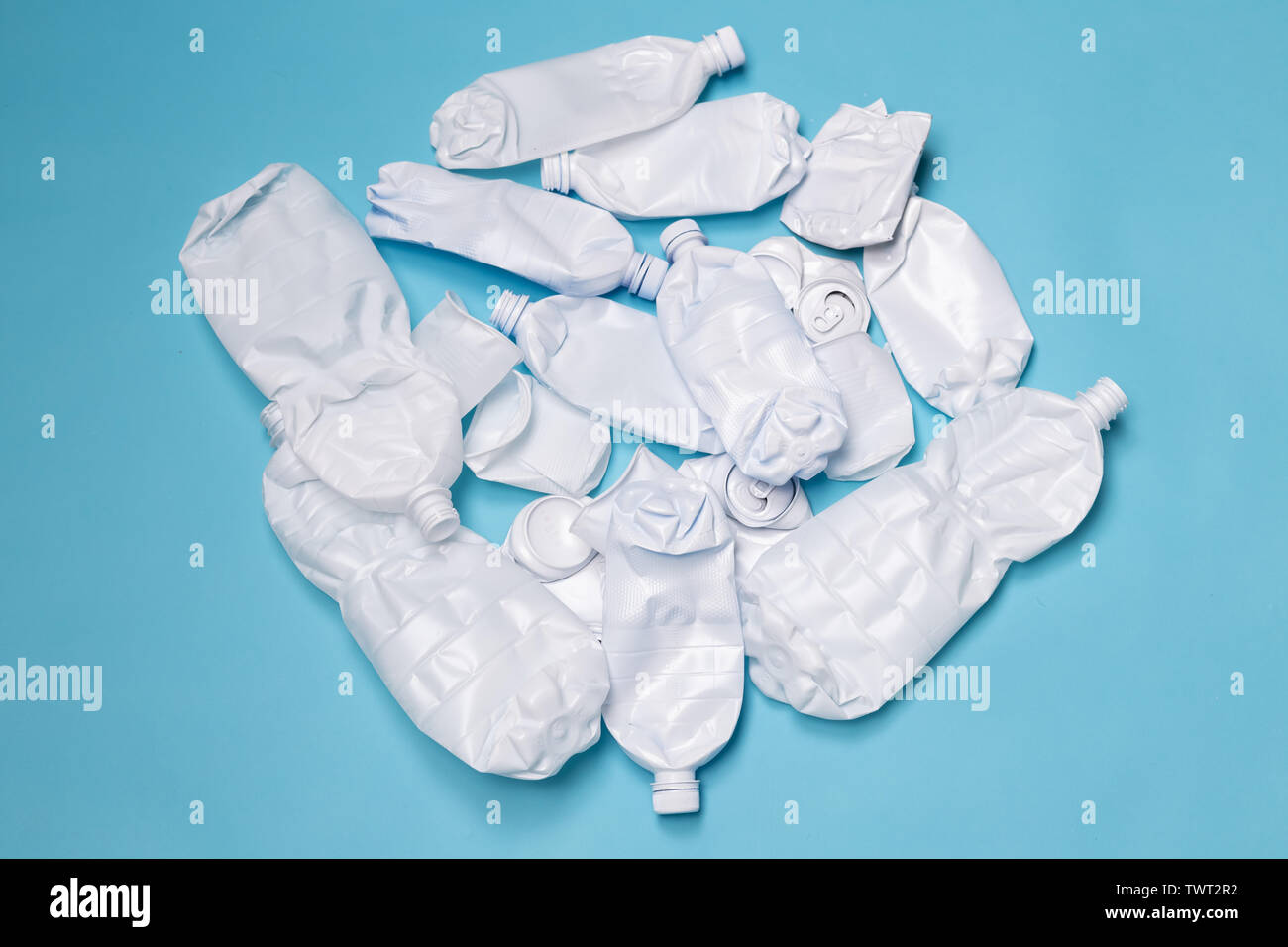 Crumpled plastic bottles lies on a blue background. Concept of ...